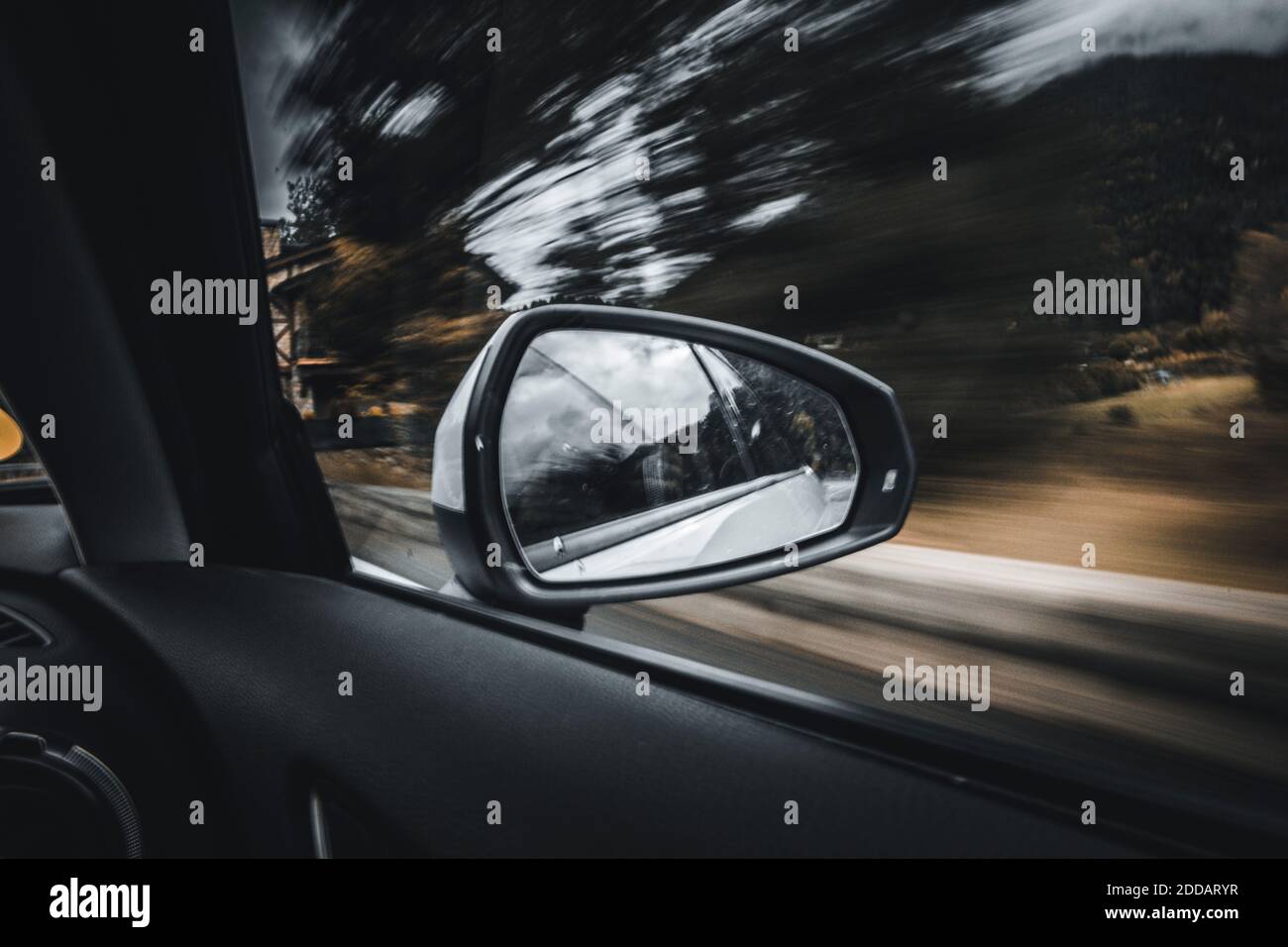 Side-view mirror reflection of moving car Stock Photo - Alamy