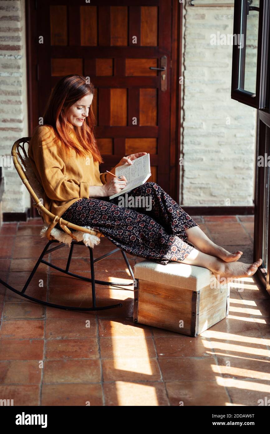 Woman sitting in chair writing hi-res stock photography and images - Alamy