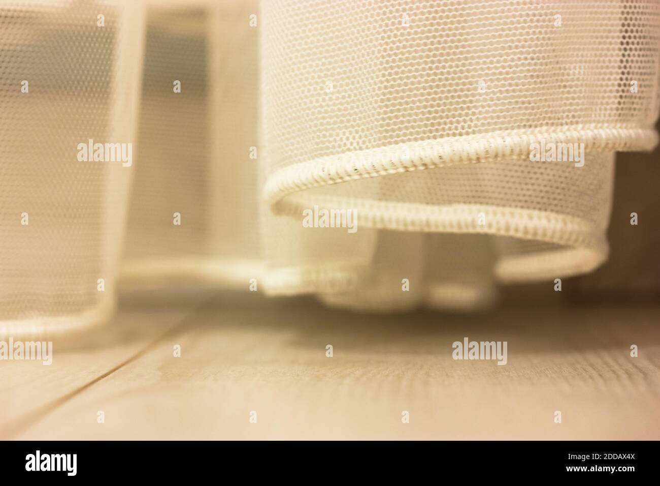 White tulle on the window and white parquet close-up, interior details ...
