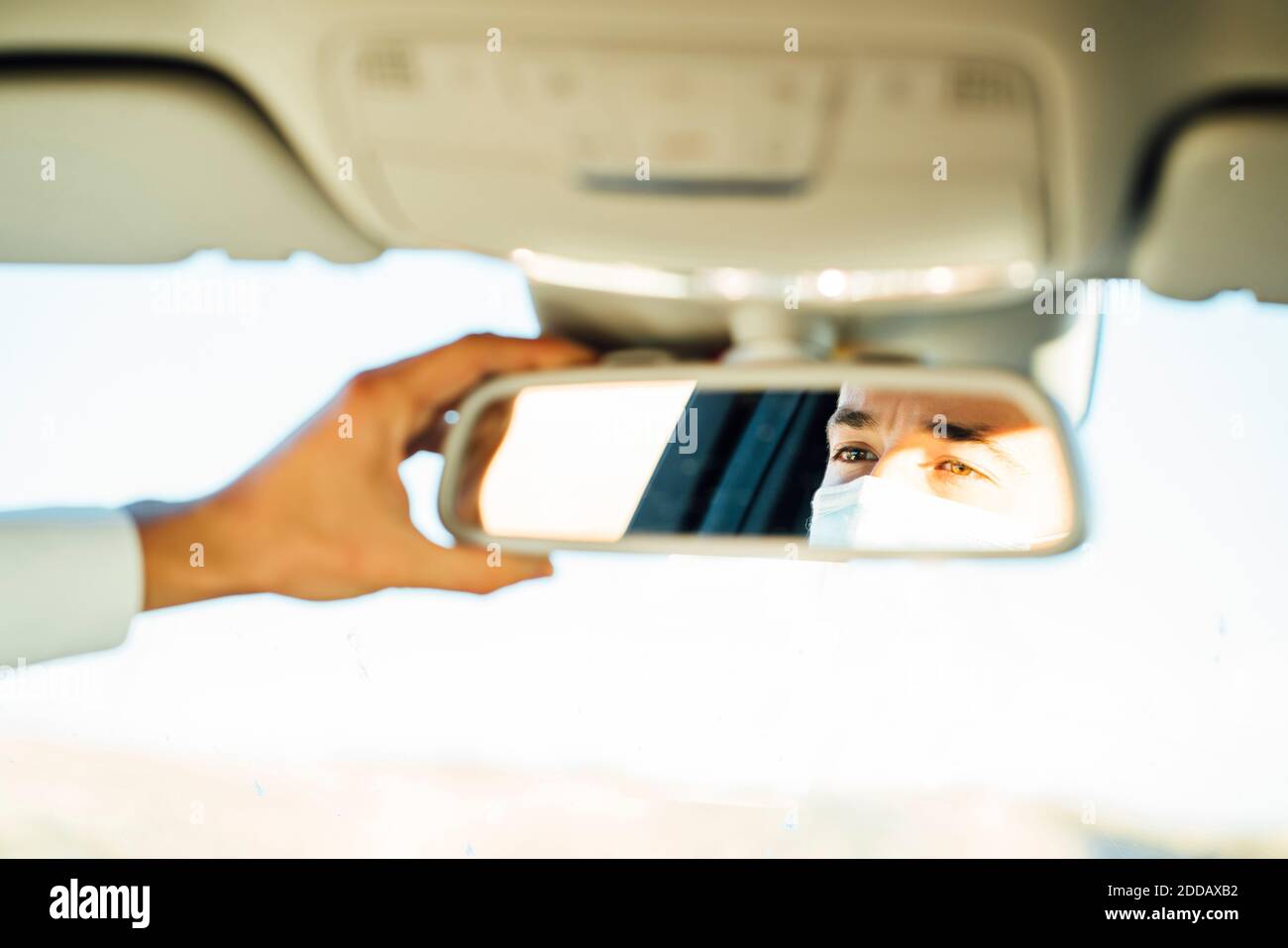 Man adjusting rear-view mirror in car Stock Photo - Alamy