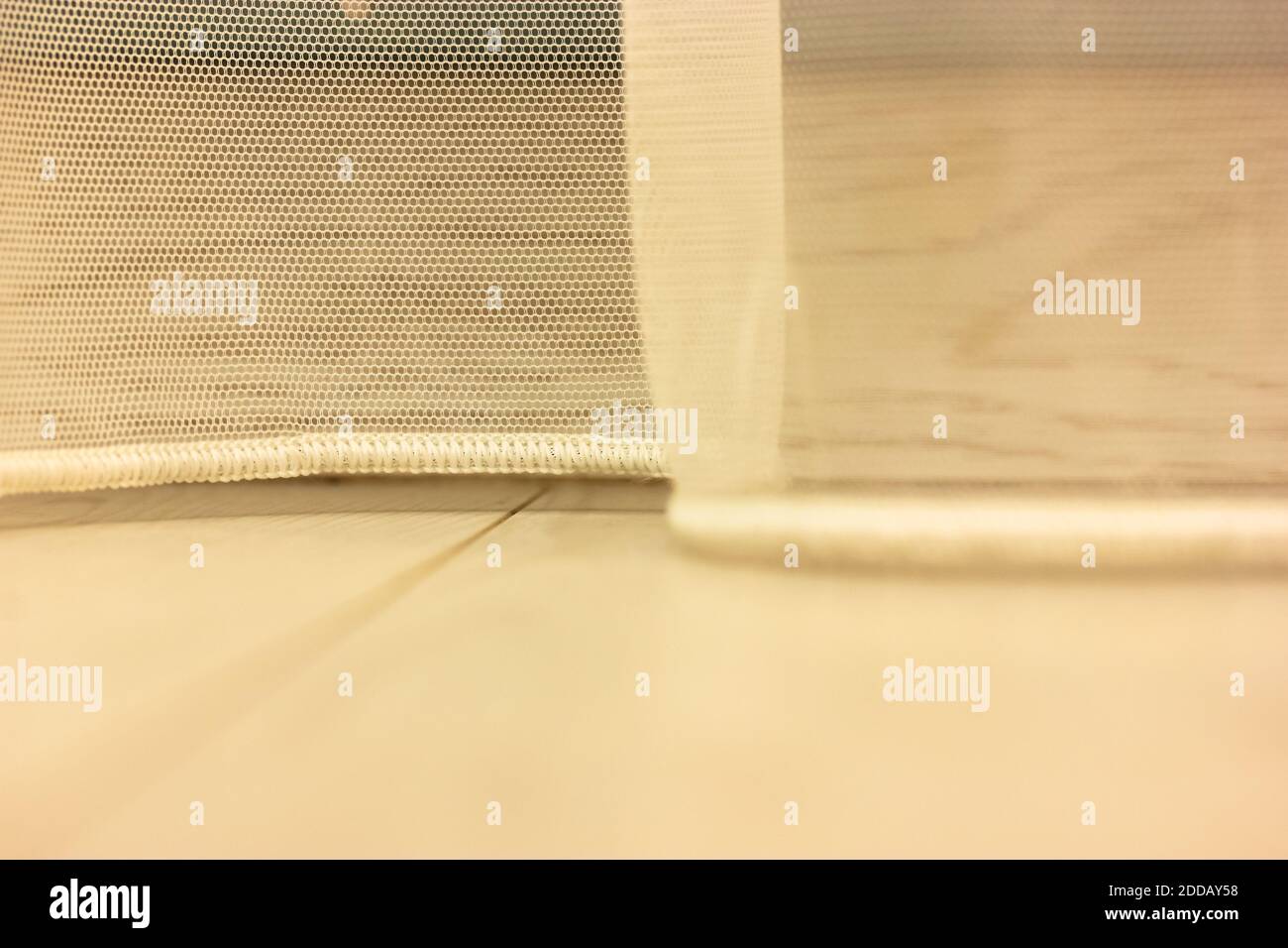 White tulle on the window and white parquet close-up, interior details ...