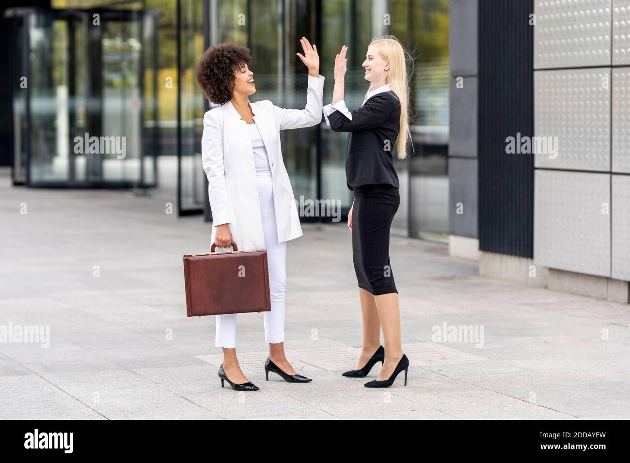 Two young women giving high five hi-res stock photography and images ...