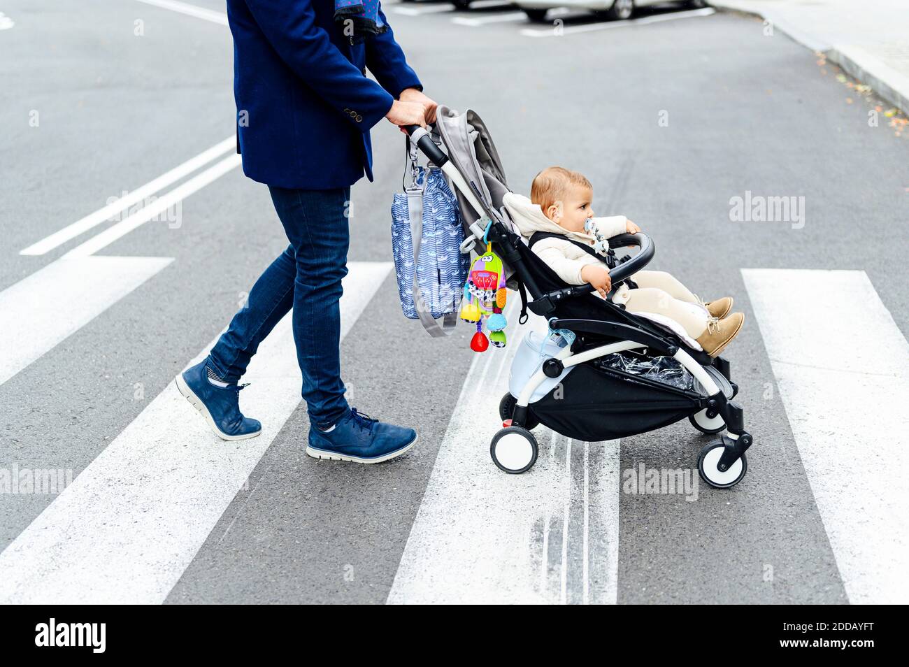 Man with baby stroller crossing road in city Stock Photo - Alamy