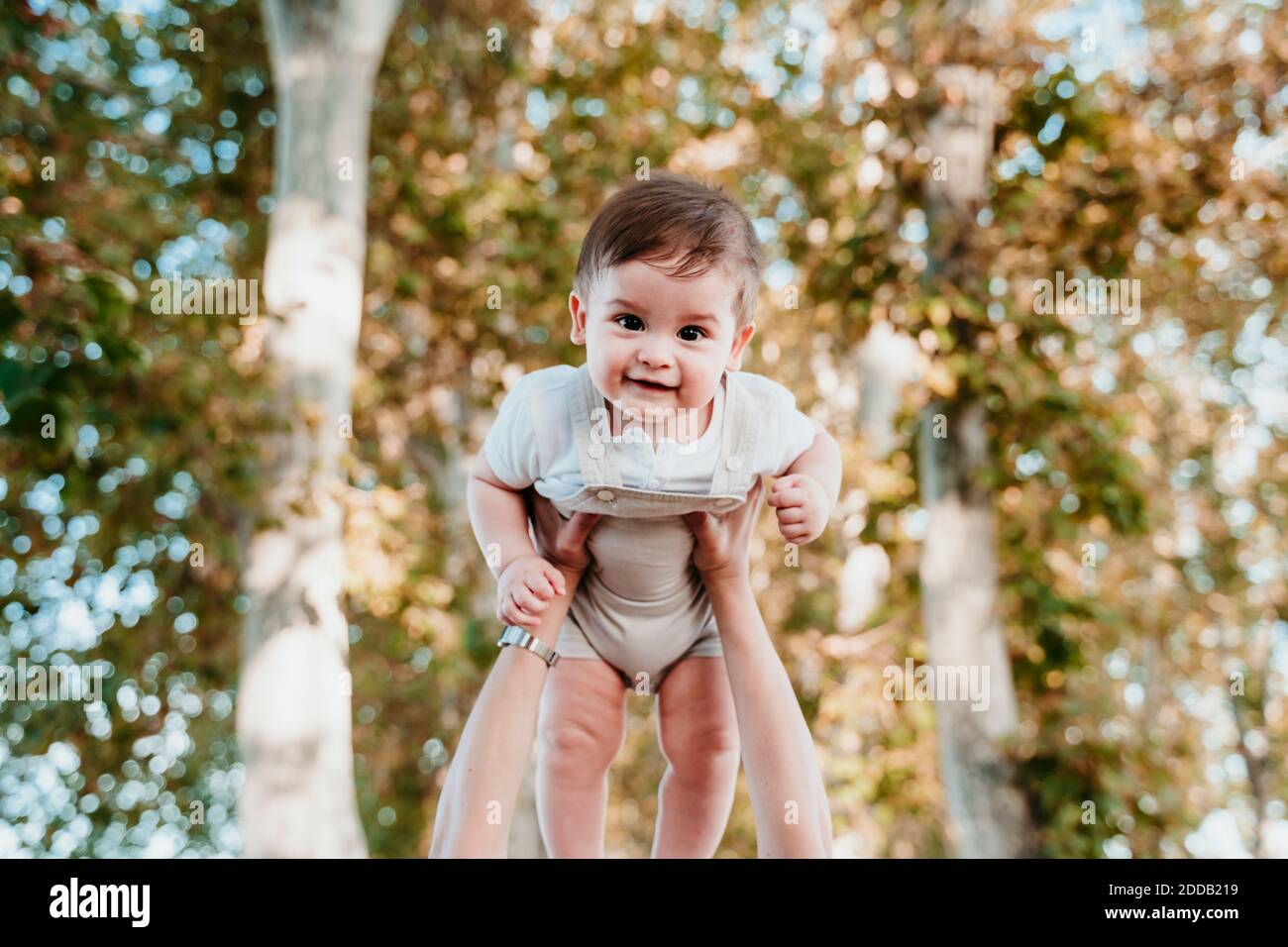 Mother hands picking up baby outdoors Stock Photo - Alamy