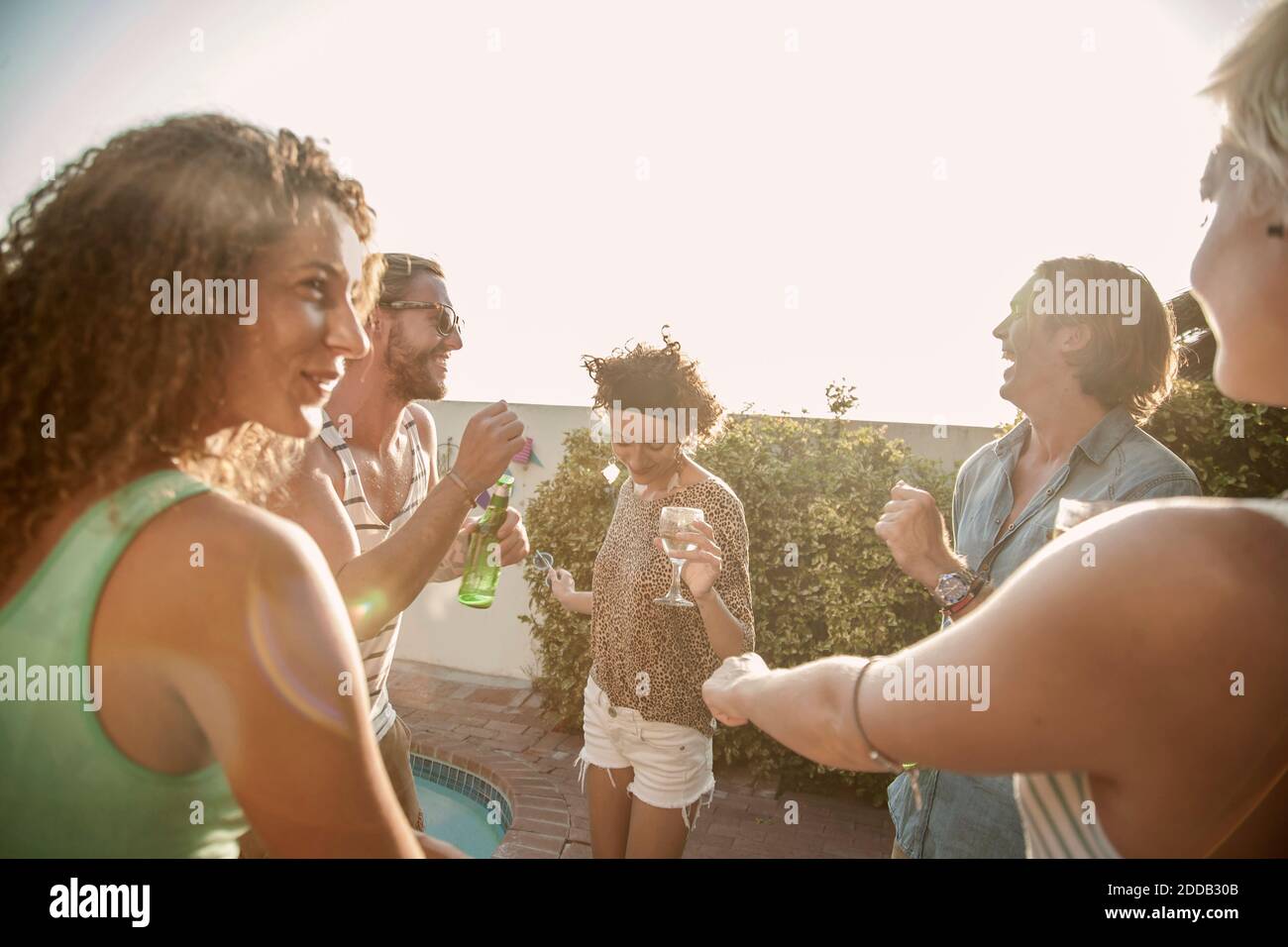 Happy friends dancing while enjoying pool party at sunset Stock Photo ...