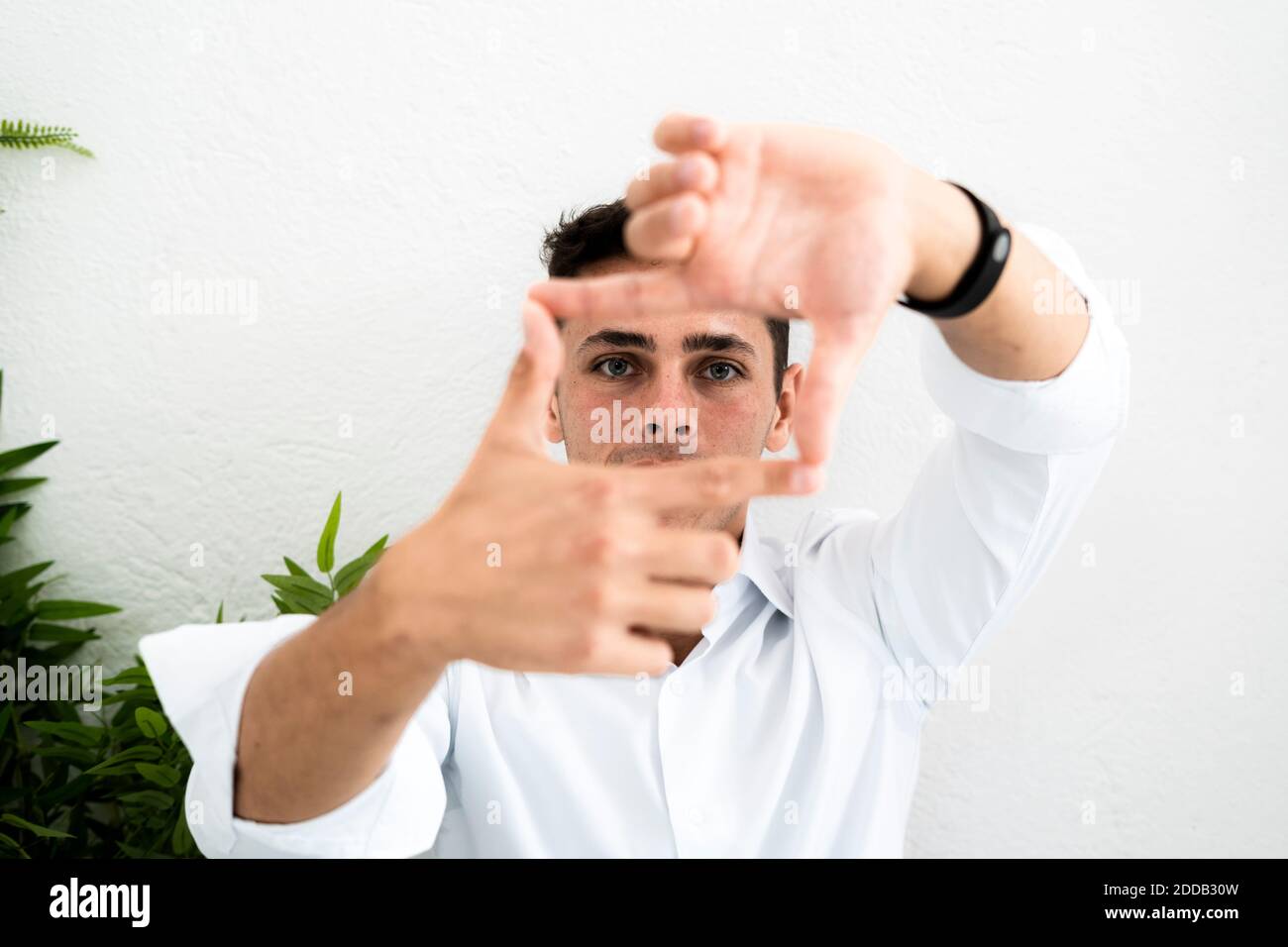 Male entrepreneur making square shape from fingers and thumbs against ...