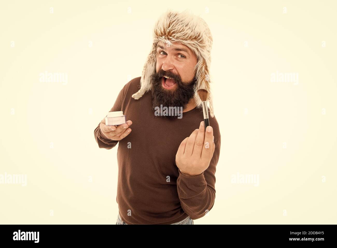 Applying makeup face tone. Powder cosmetics. Man bearded stylist wear ...