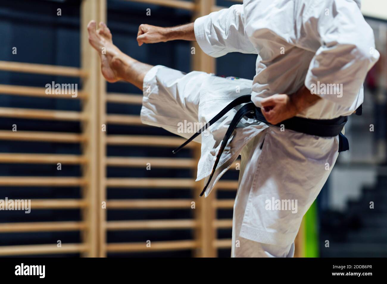 Mature man kicking while practicing karate in class Stock Photo - Alamy