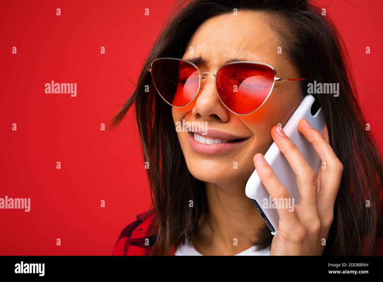 distraught girl on a red background speaks on phone, close-up Stock ...