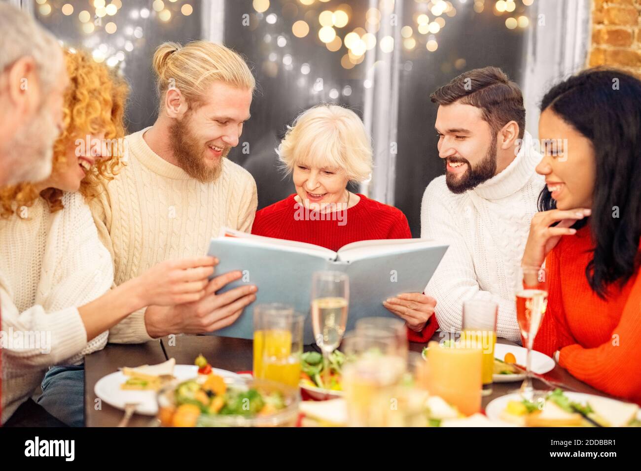 United mixed race family spending time together, looking photo album ...