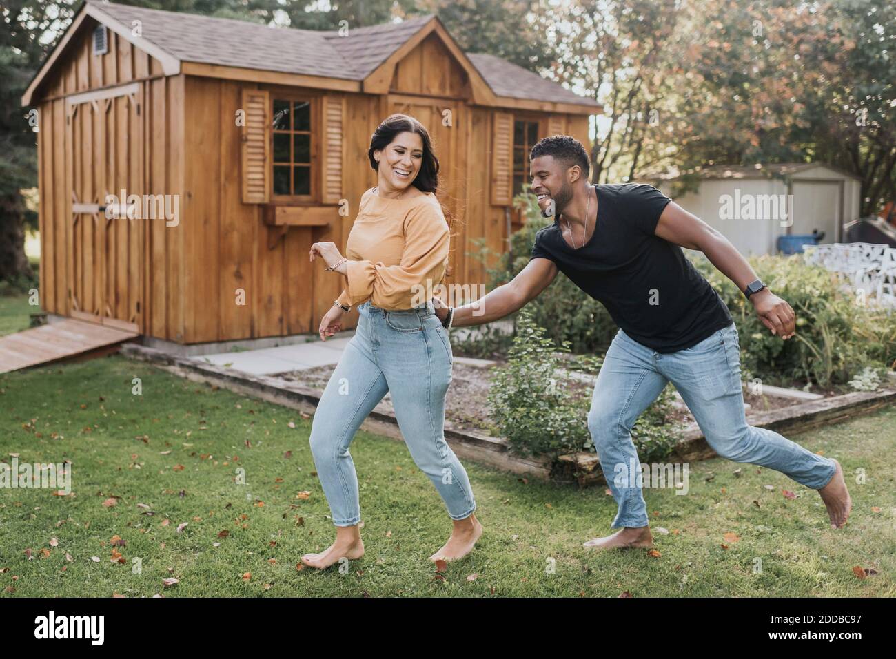 Man catching woman from behind while running at backyard Stock Photo ...