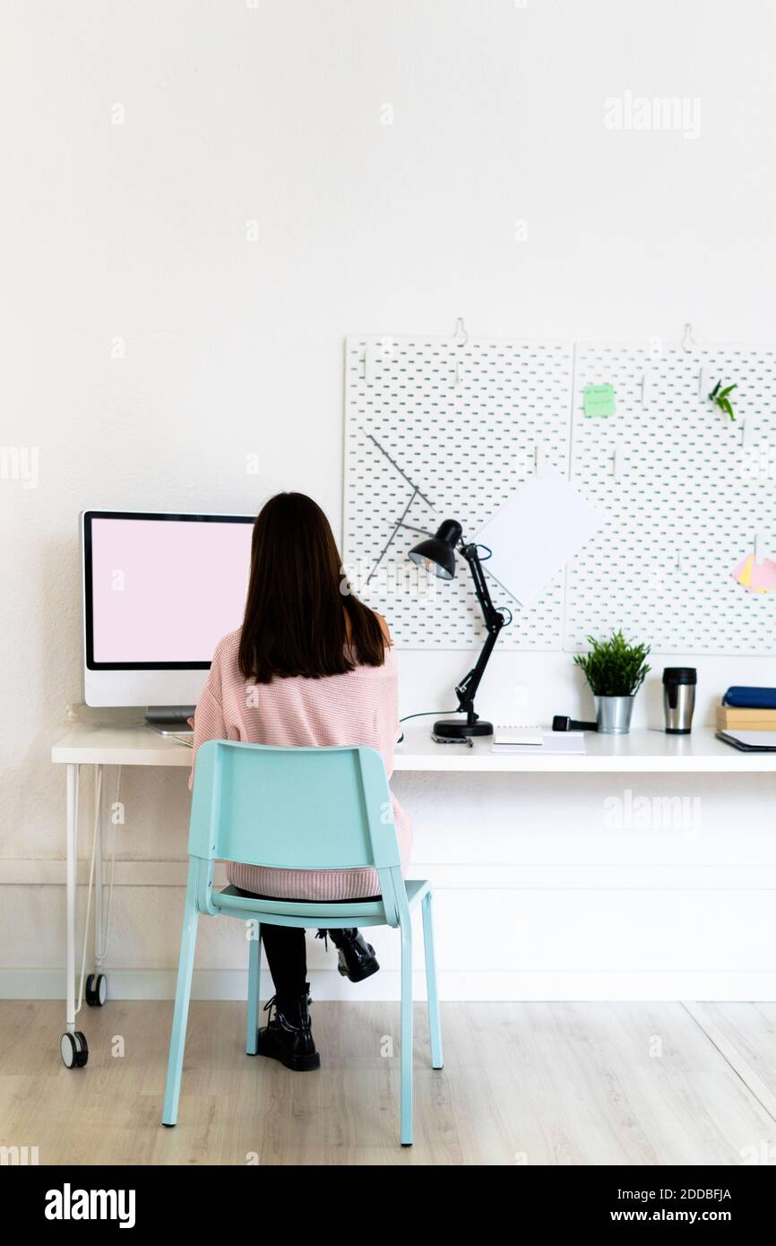 Female blogger using computer at desk in loft apartment Stock Photo - Alamy