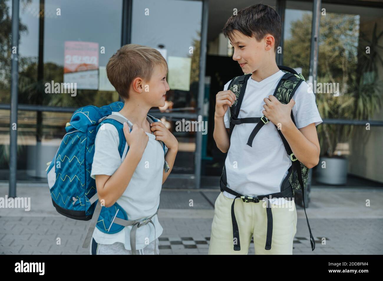Brothers looking at each other while standing in front of school ...