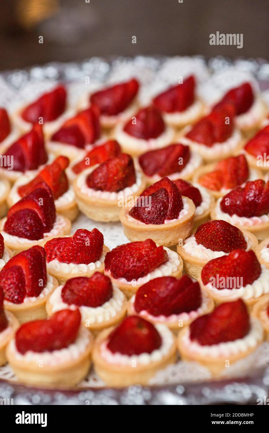 Small fruit tarts on tray at catering venue. Bright colored tarts in a ...