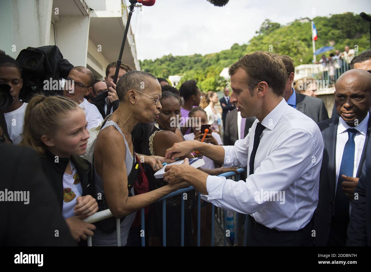 French President Emmanuel Macron listens to a bystander as he leaves ...