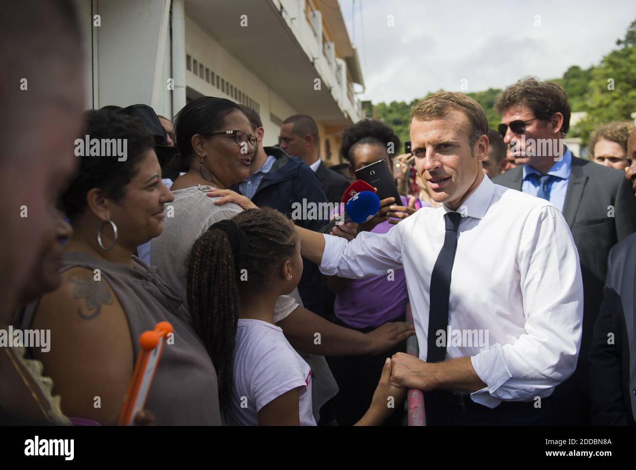 French President Emmanuel Macron listens to a bystander as he leaves ...