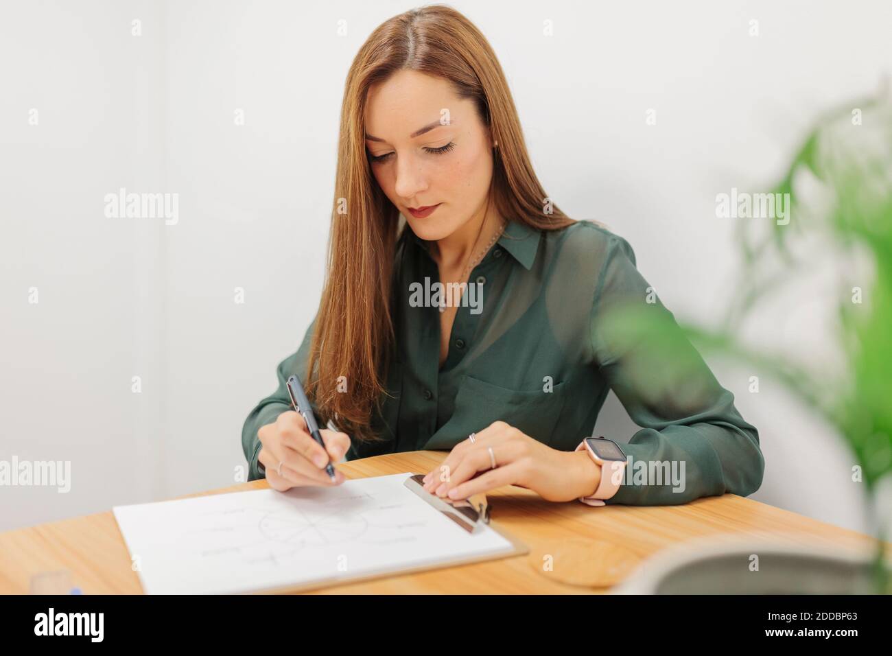 Female psychologist working while sitting at office Stock Photo - Alamy
