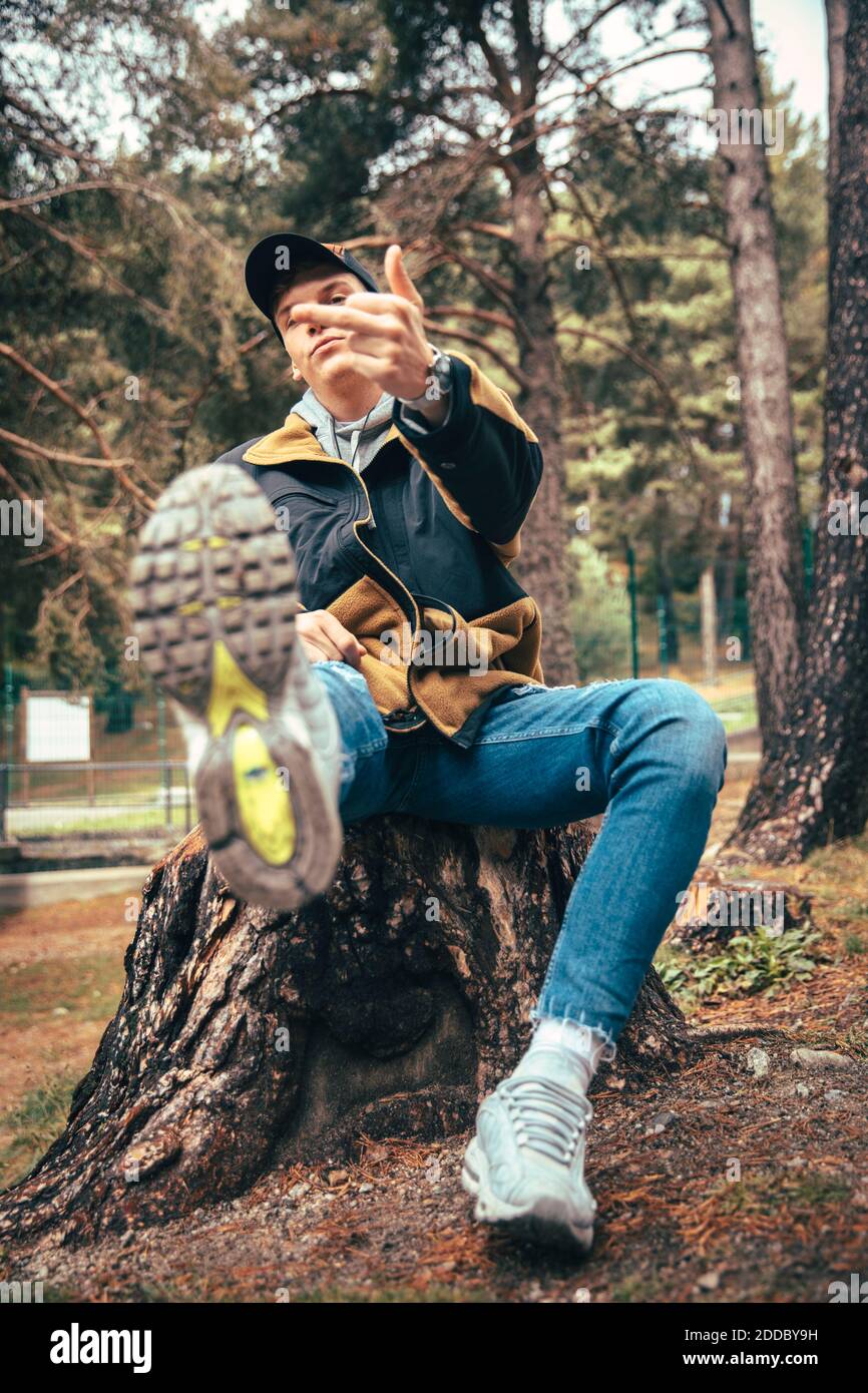 Young man sitting on log hi-res stock photography and images - Alamy