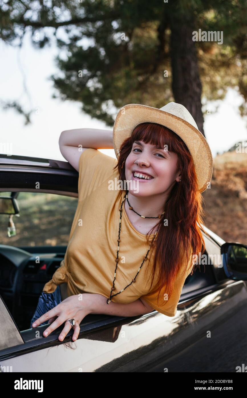 Portrait happy young woman leaning out window hi-res stock photography ...