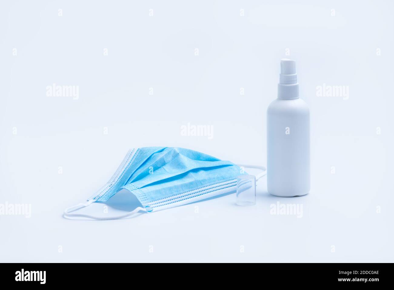Blue Surgical protective mask and Alcohol Disinfectant spray bottle on ...