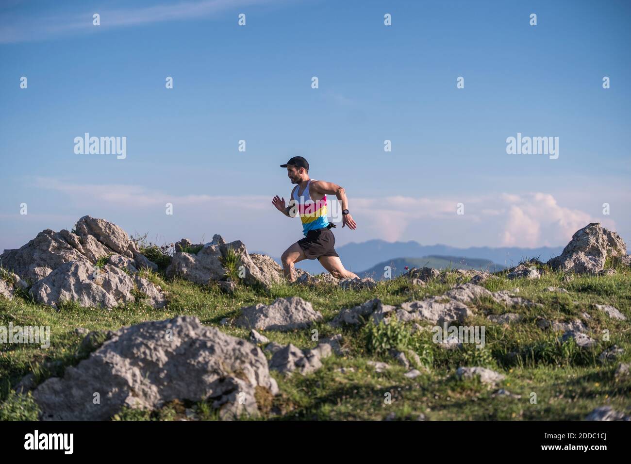 Sportsman running on mountain against clear sky Stock Photo - Alamy