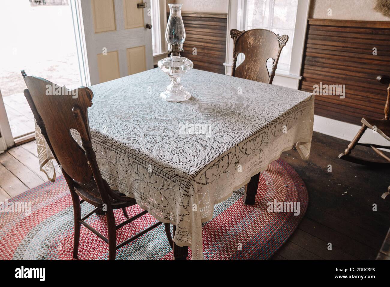 Interior of a kitchen, with antique table, lace tablecloth, and a ...