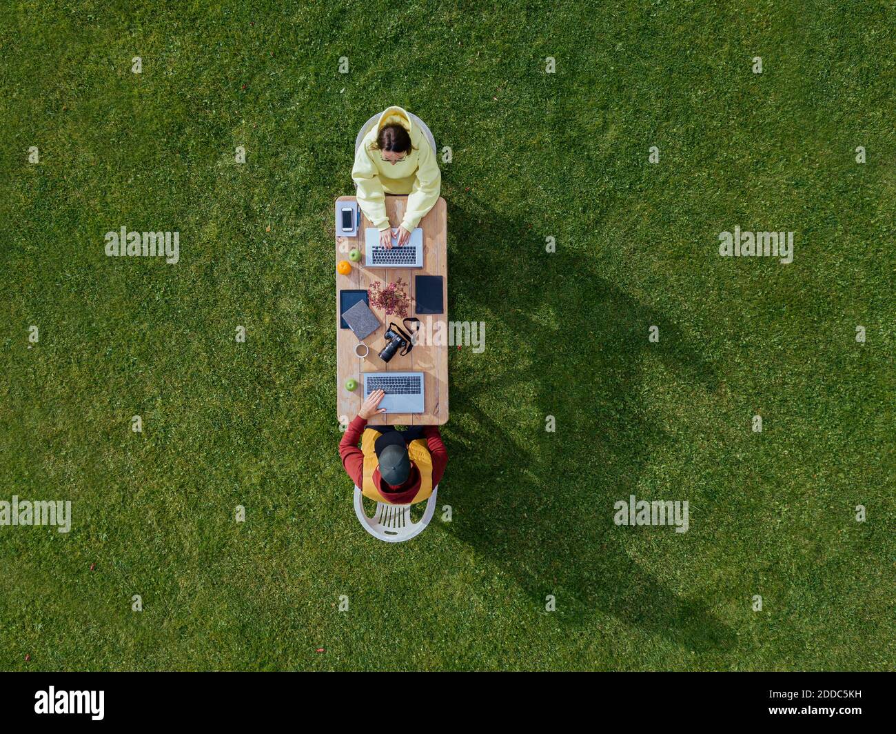 Aerial view of man and woman working on laptops at coffee table set on ...