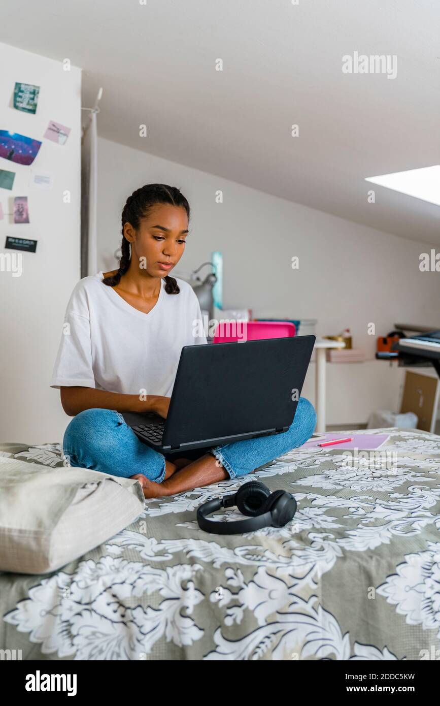 Teenage girl using laptop while sitting at home Stock Photo - Alamy