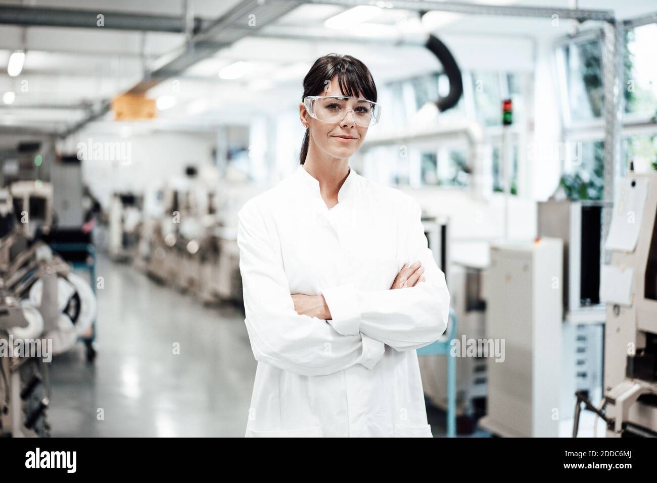 Confident female scientist standing with arms crossed in bright laboratory Stock Photo - Alamy