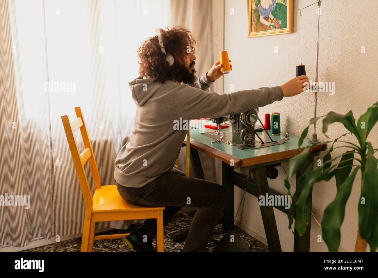 Mature man adjusting thread on sewing machine Stock Photo - Alamy