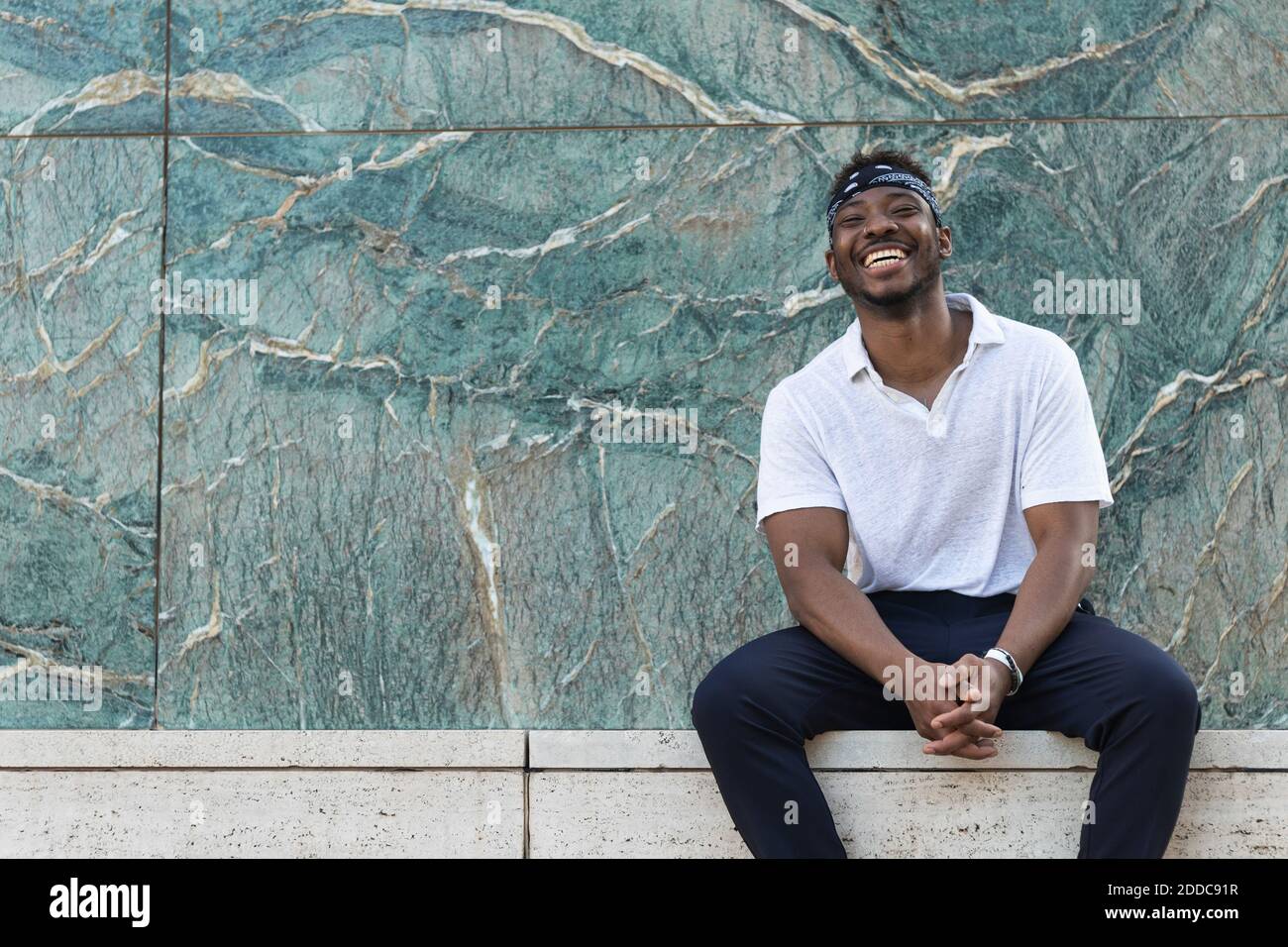 Man sitting against wall hands hi-res stock photography and images - Alamy