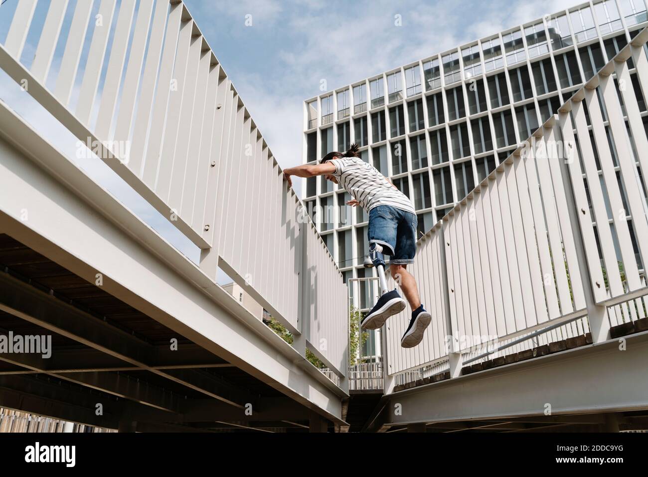 Amputed man against bridge railing in city Stock Photo - Alamy