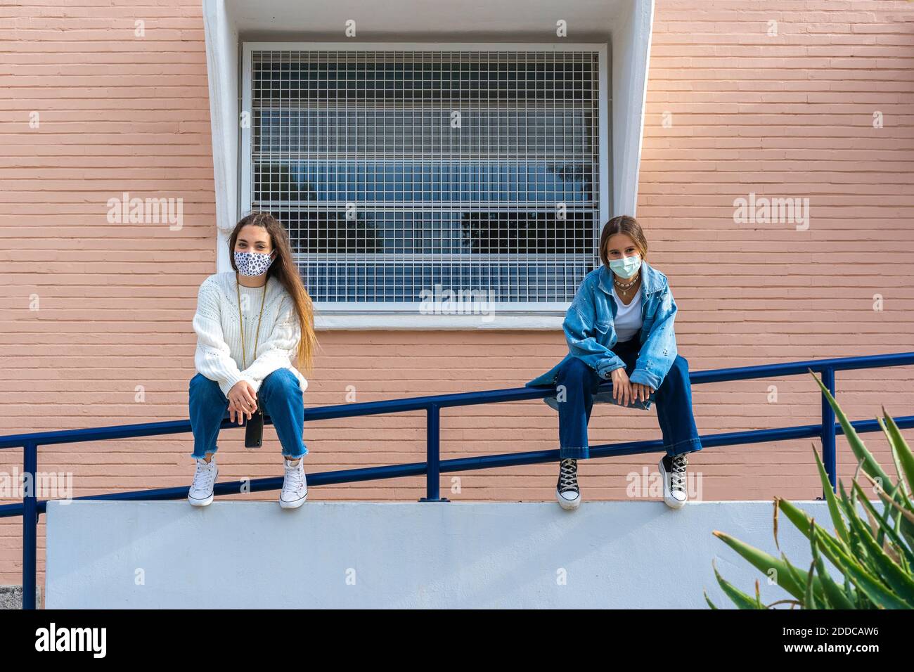 Teenage friends social distancing while wearing protective face mask ...