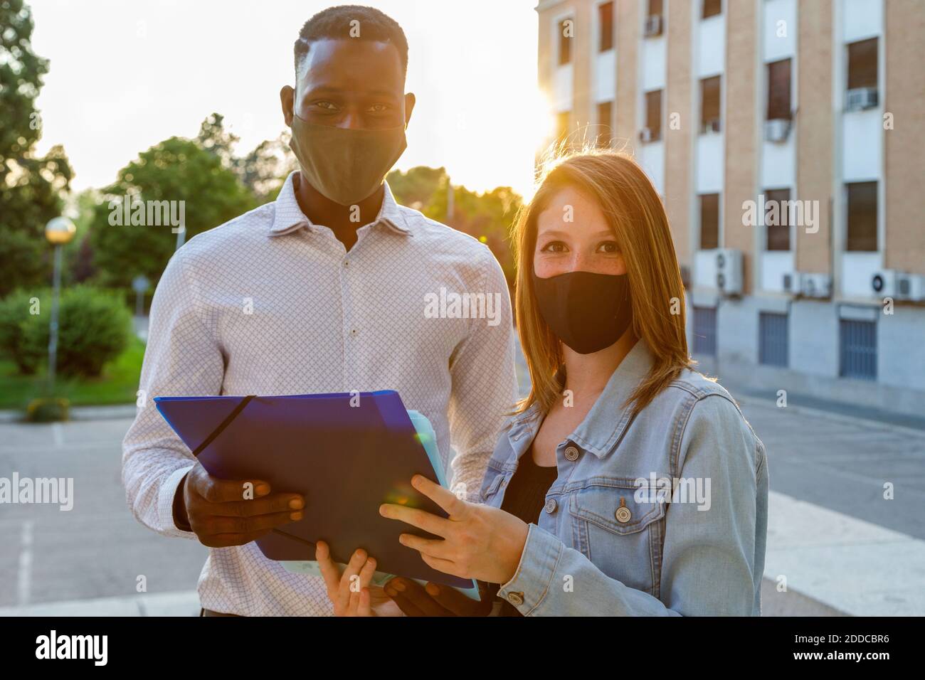 Male with female university student wearing protective face mask while ...