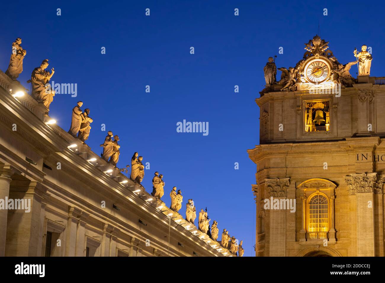 Illuminated saint statues on St. Peter's Basilica against clear blue ...