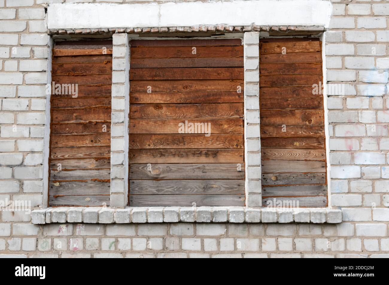Brick building with wooden windows. The windows are filled with wood ...