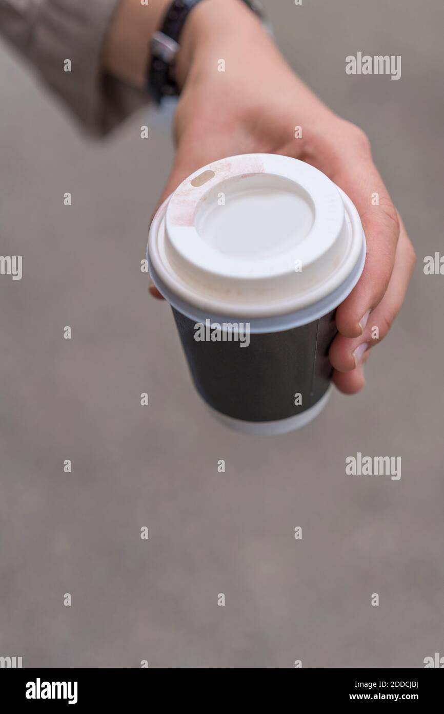 Hand of woman's hand holding disposable coffee cup Stock Photo - Alamy
