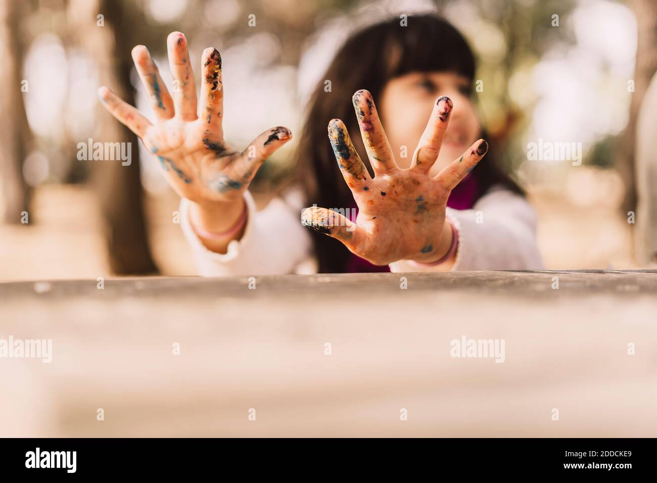 Girl with messy hands at picnic table in park Stock Photo - Alamy
