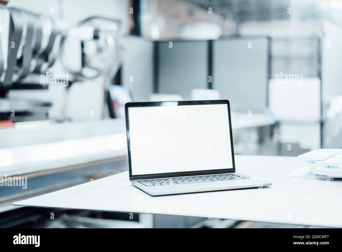 Laptop with blank screen on table in industry Stock Photo - Alamy