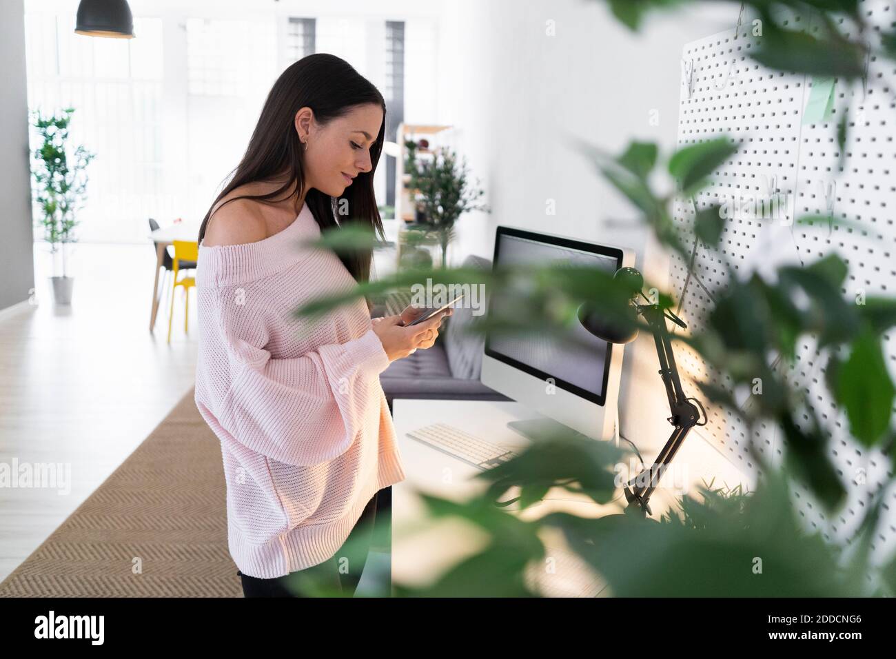 Beautiful young female blogger using mobile phone while standing at ...