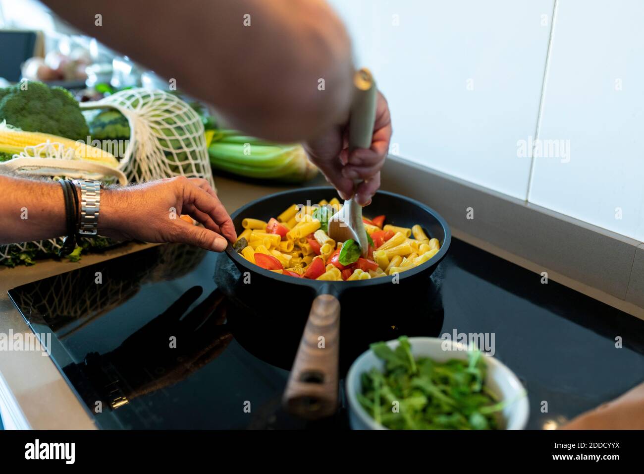Human hand preparing pasta in kitchen Stock Photo - Alamy