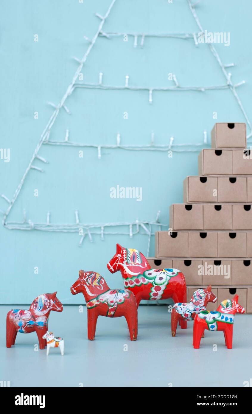 Red Dala horse figurines, stack of cardboard boxes and Christmas lights ...