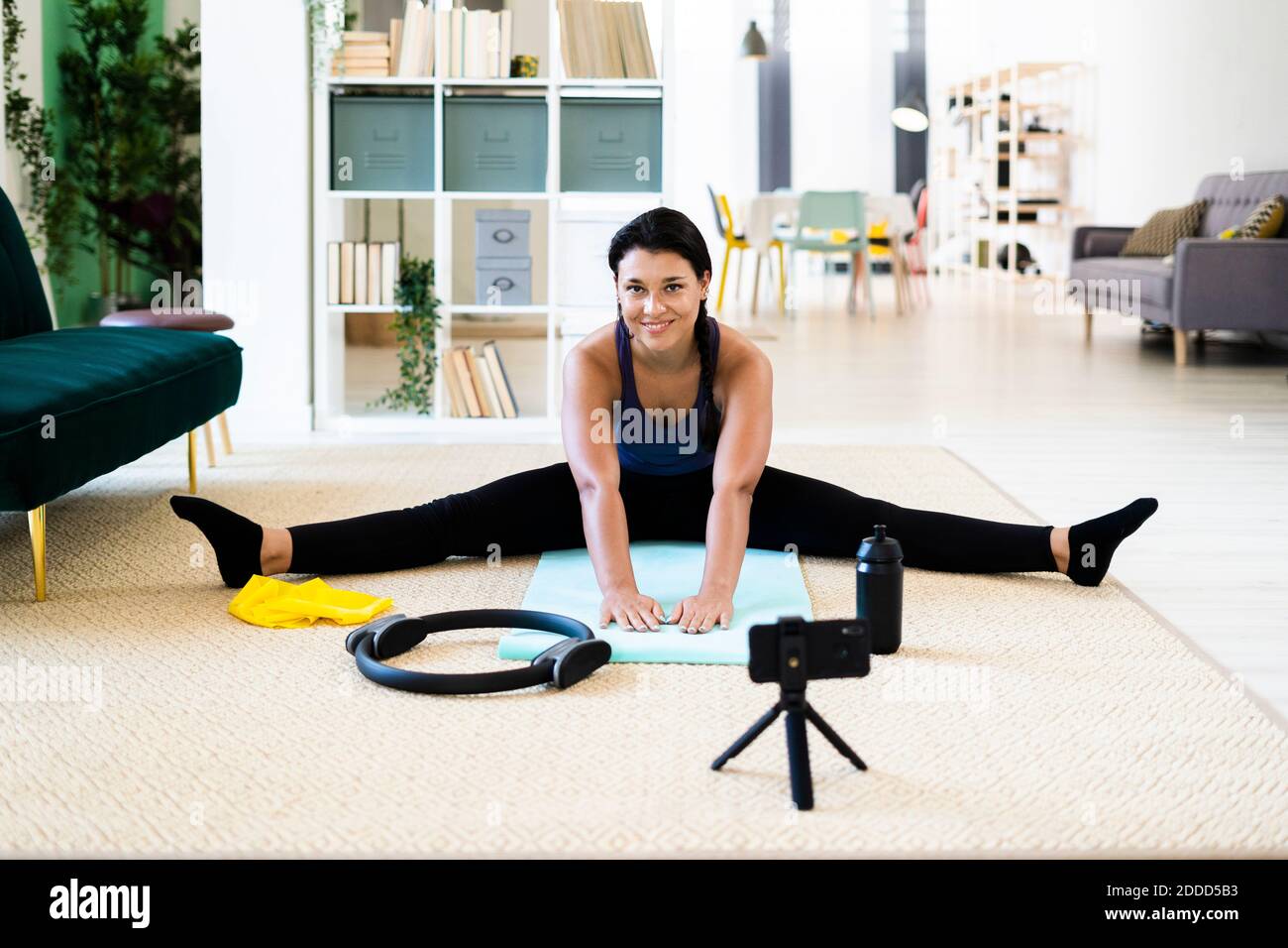Female influencer video recording on camera while doing stretching ...
