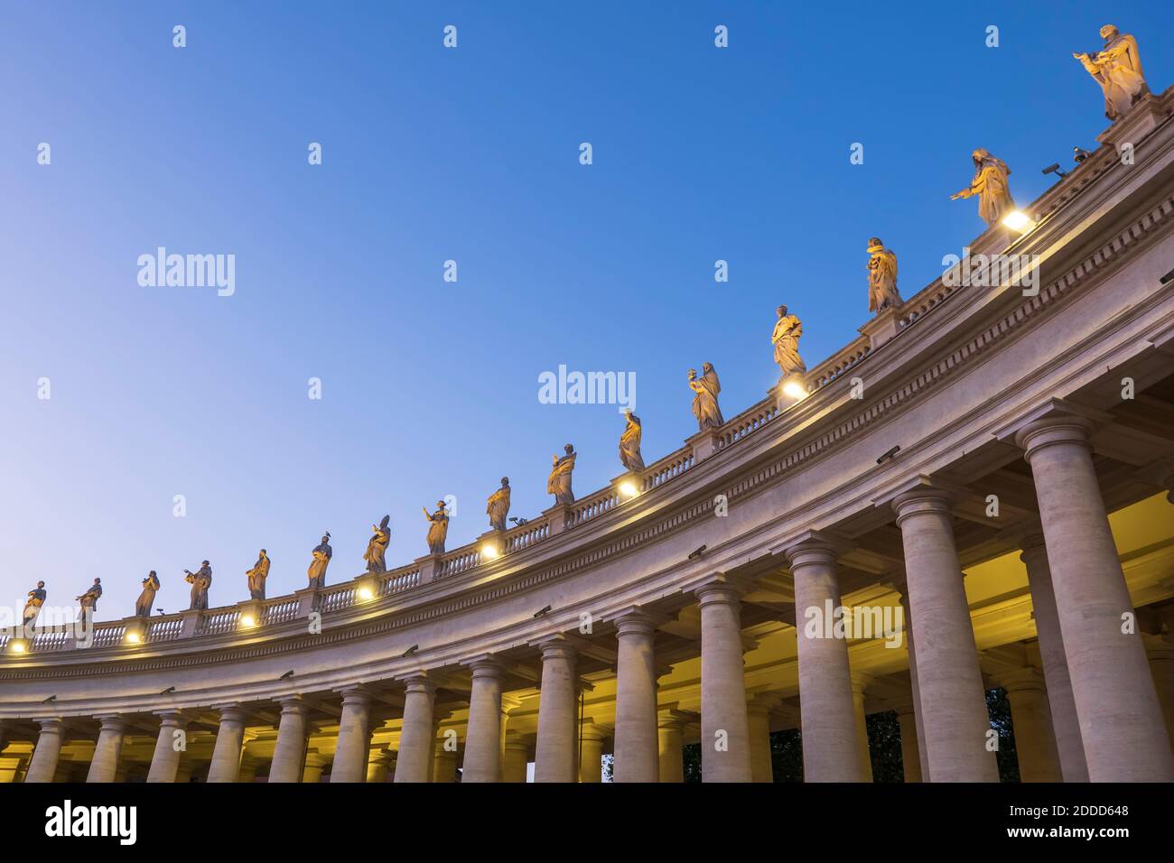 Illuminated saint statues on St. Peter's Basilica against clear blue ...
