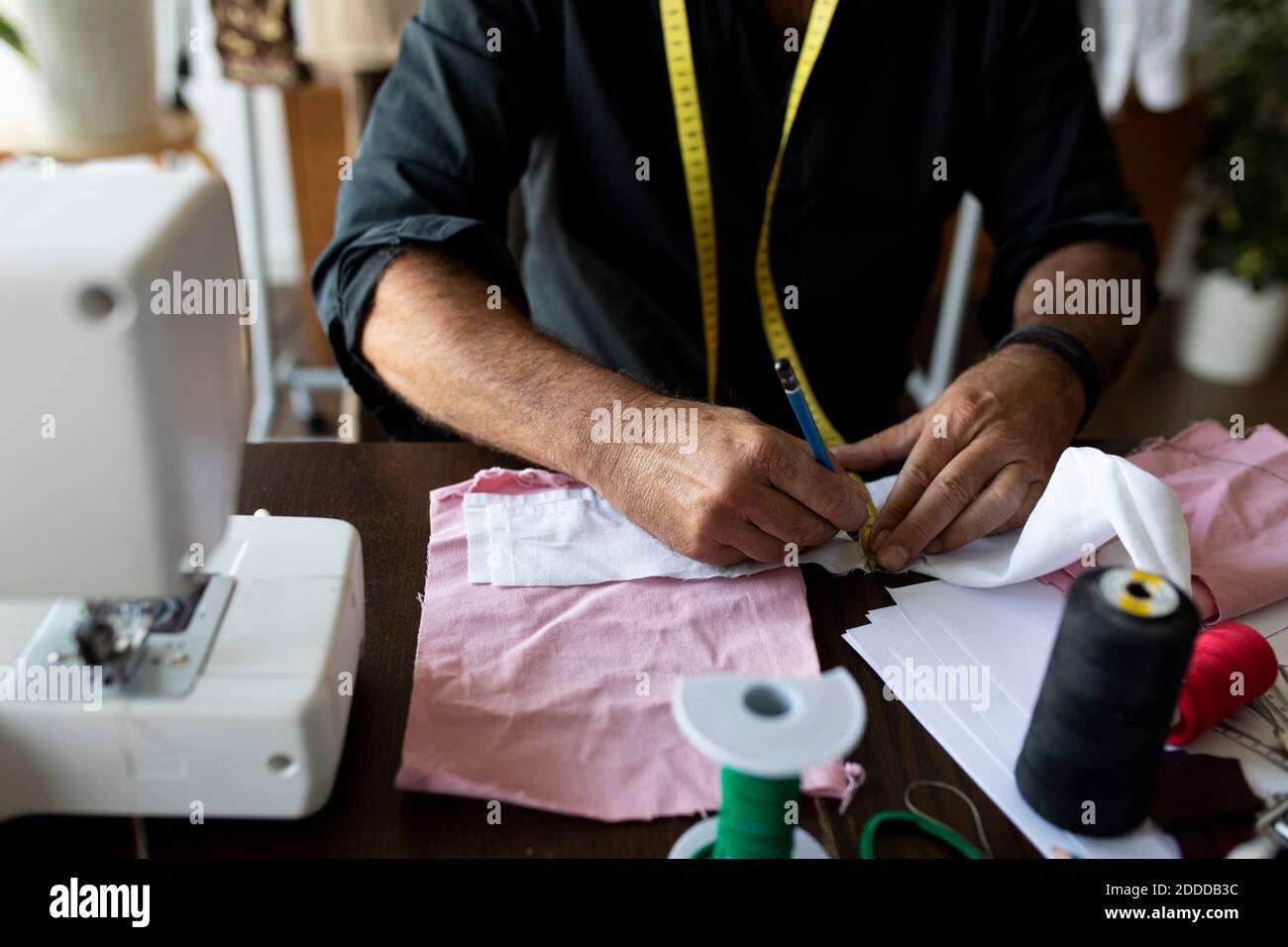 Male tailor marking on fabric with pencil at work studio Stock Photo ...