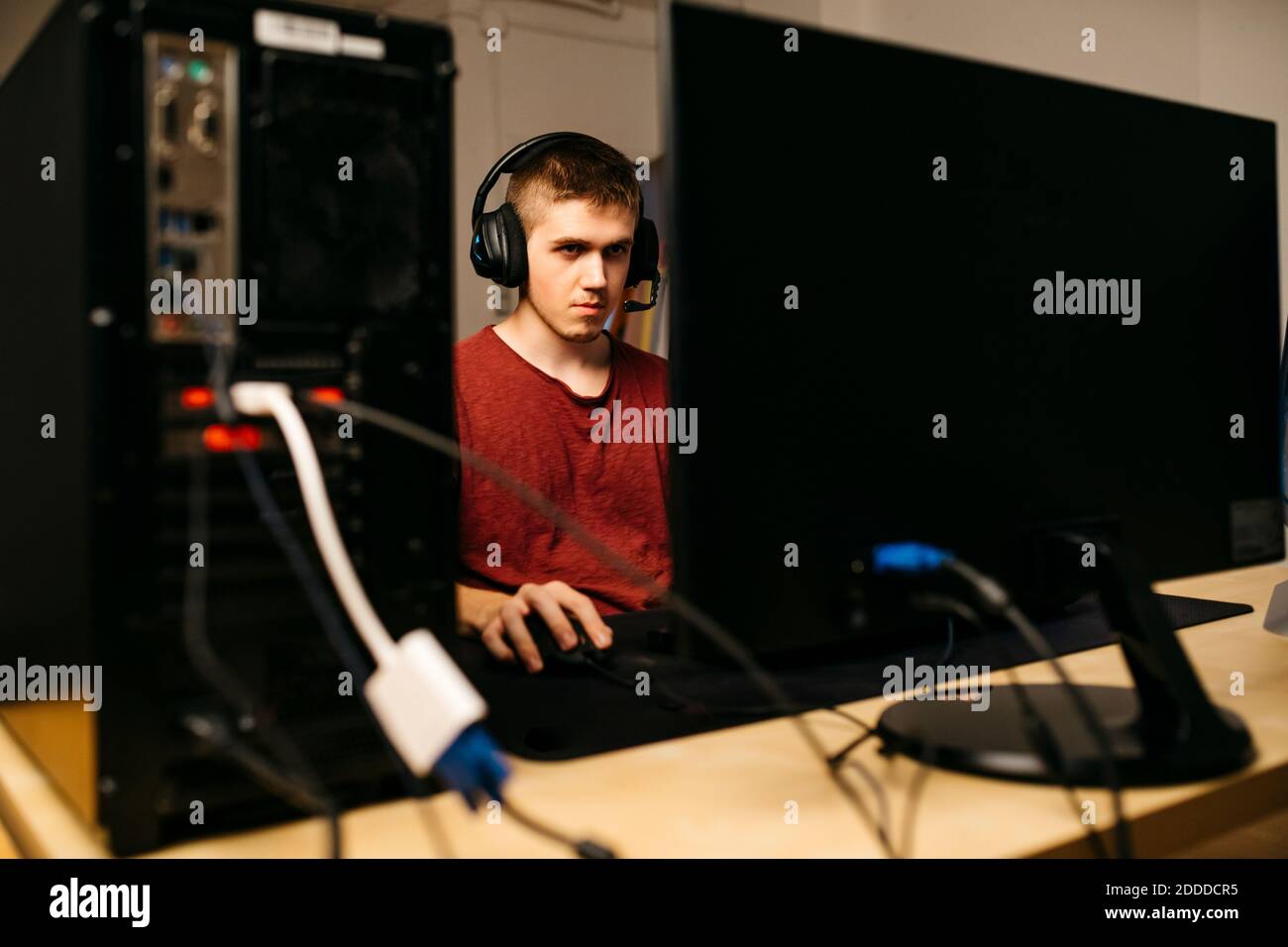 Young man playing video games with computer at desk Stock Photo - Alamy
