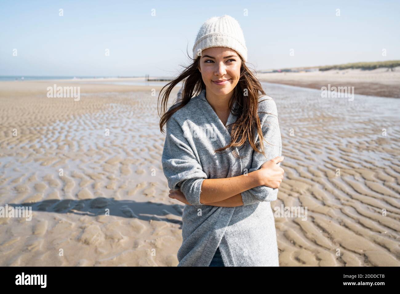 Young woman with arms crossed walking with man shadow in background at ...