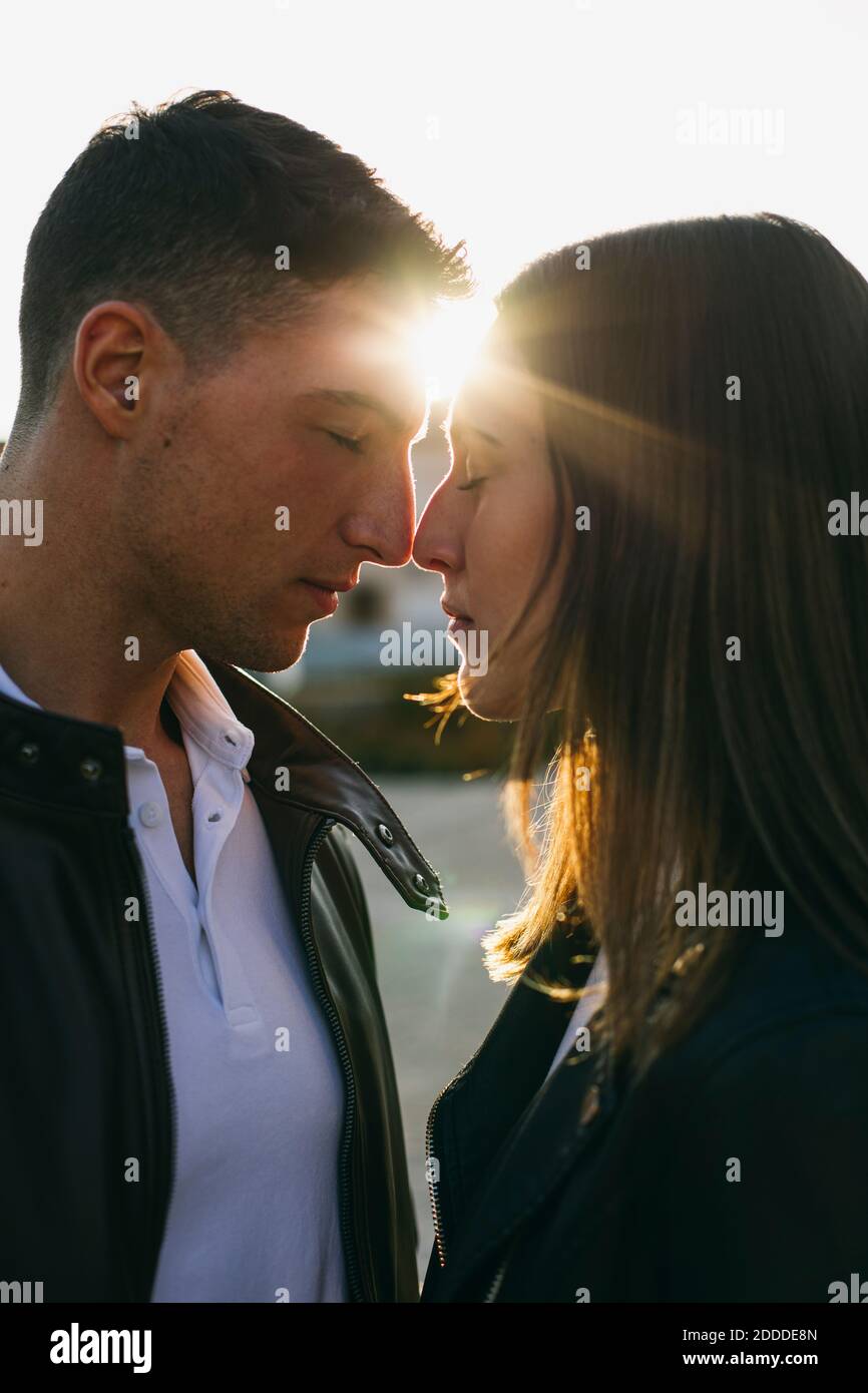 Young couple standing face to face with eyes closed during sunset Stock ...