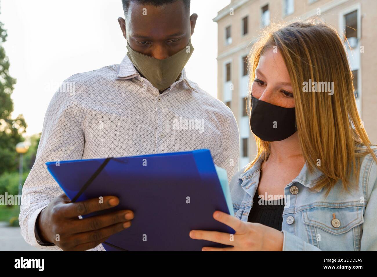 Male and female university students wearing protective face mask while ...