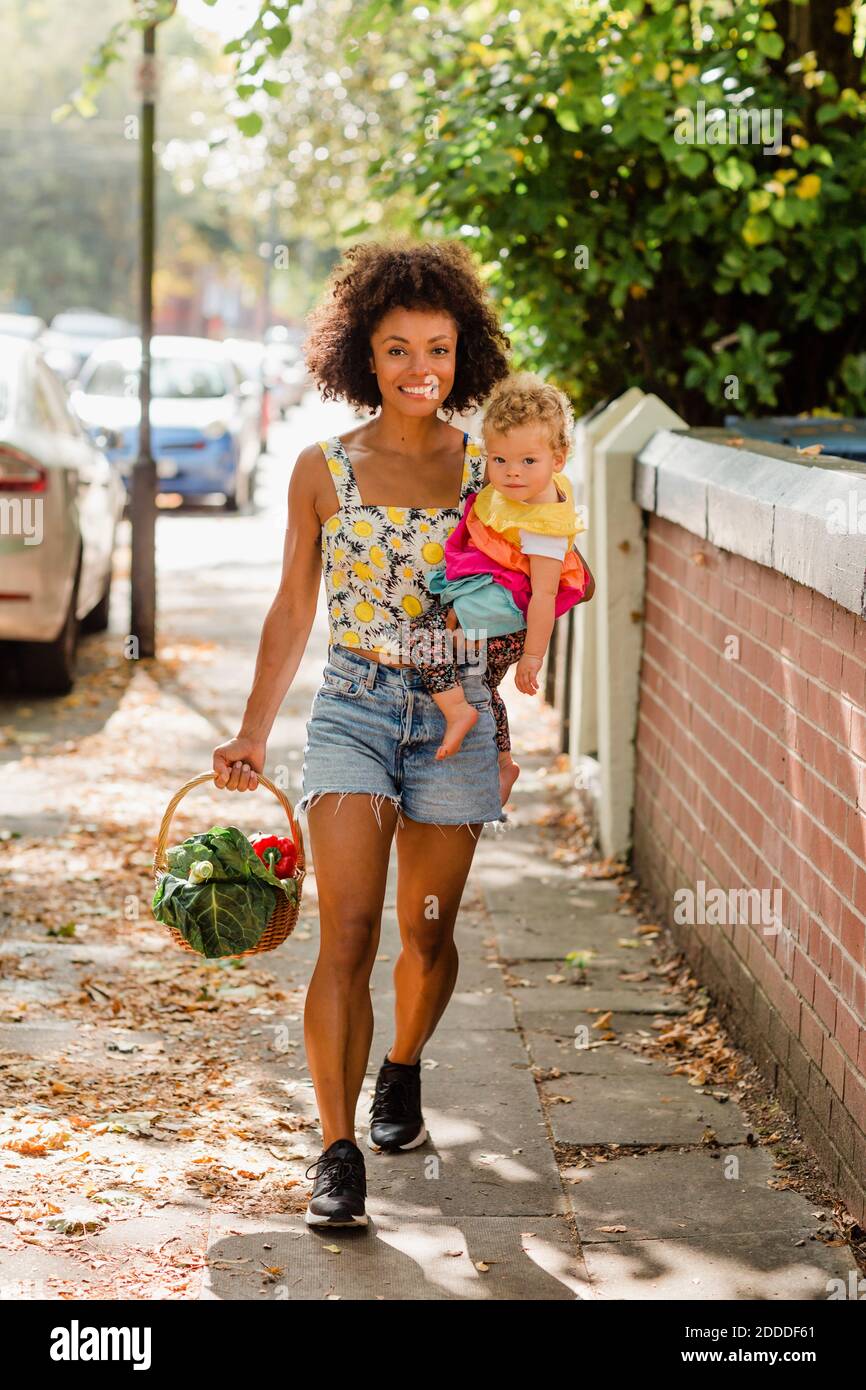 Mother carrying child walking hi-res stock photography and images - Alamy